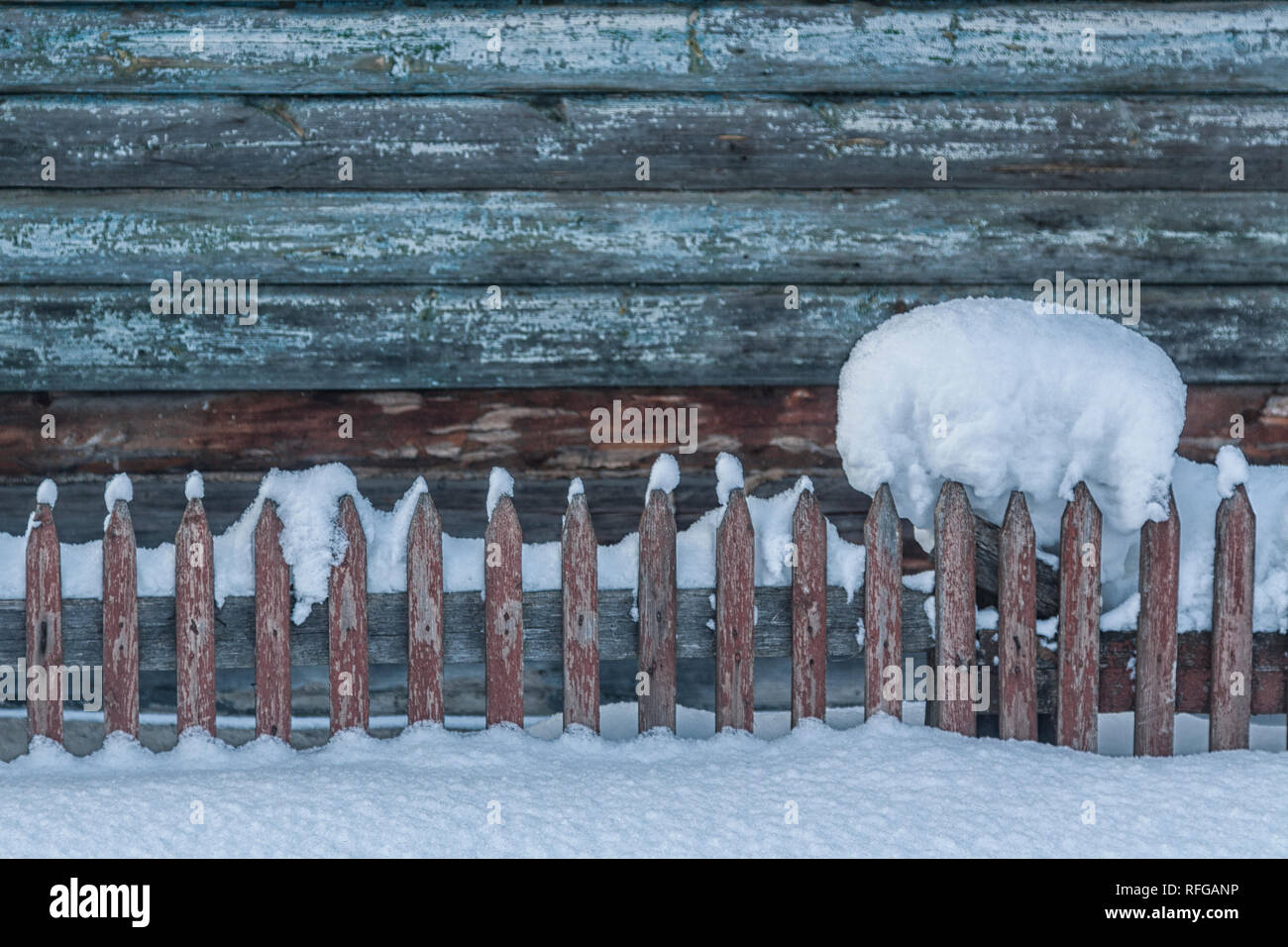 Beautiful clump of snow on a wooden fence with a snowy backdrop. There ...