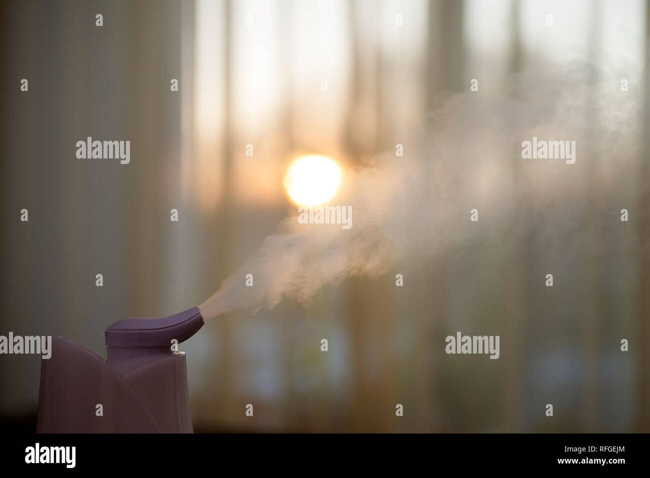 Humidifier in a living room at sunset Stock Photo - Alamy
