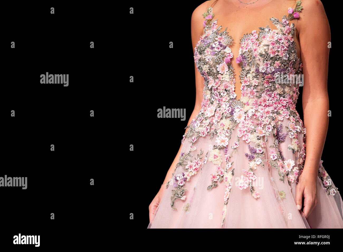 Female model walks the runway in pink dress isolated on a black ...