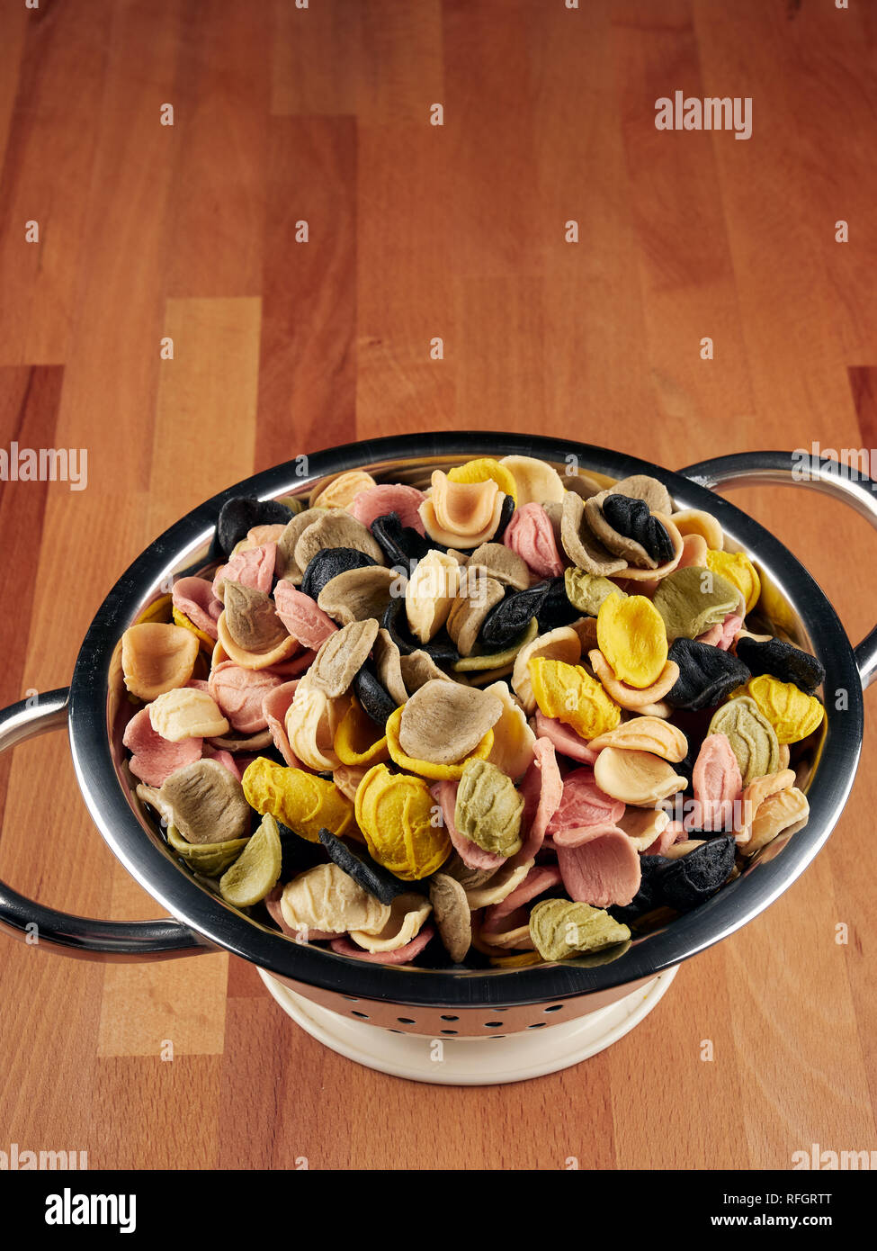Colorful uncooked orecchiette pasta in a small colander Stock Photo - Alamy
