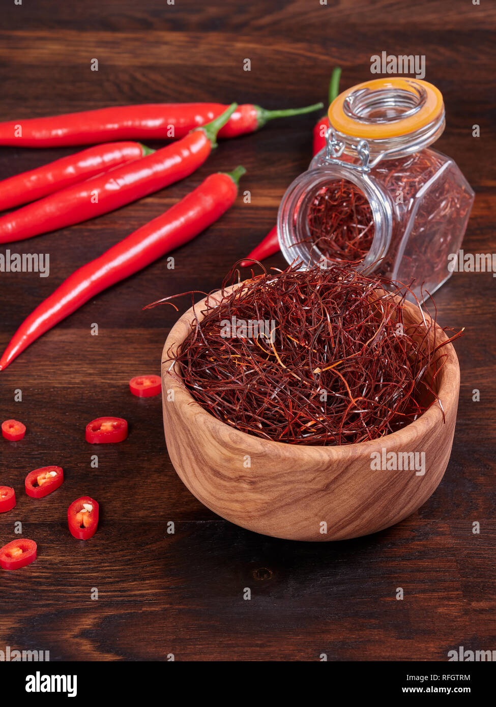 An olive wood bowl filled with thin threads of sun-dried red chili also ...