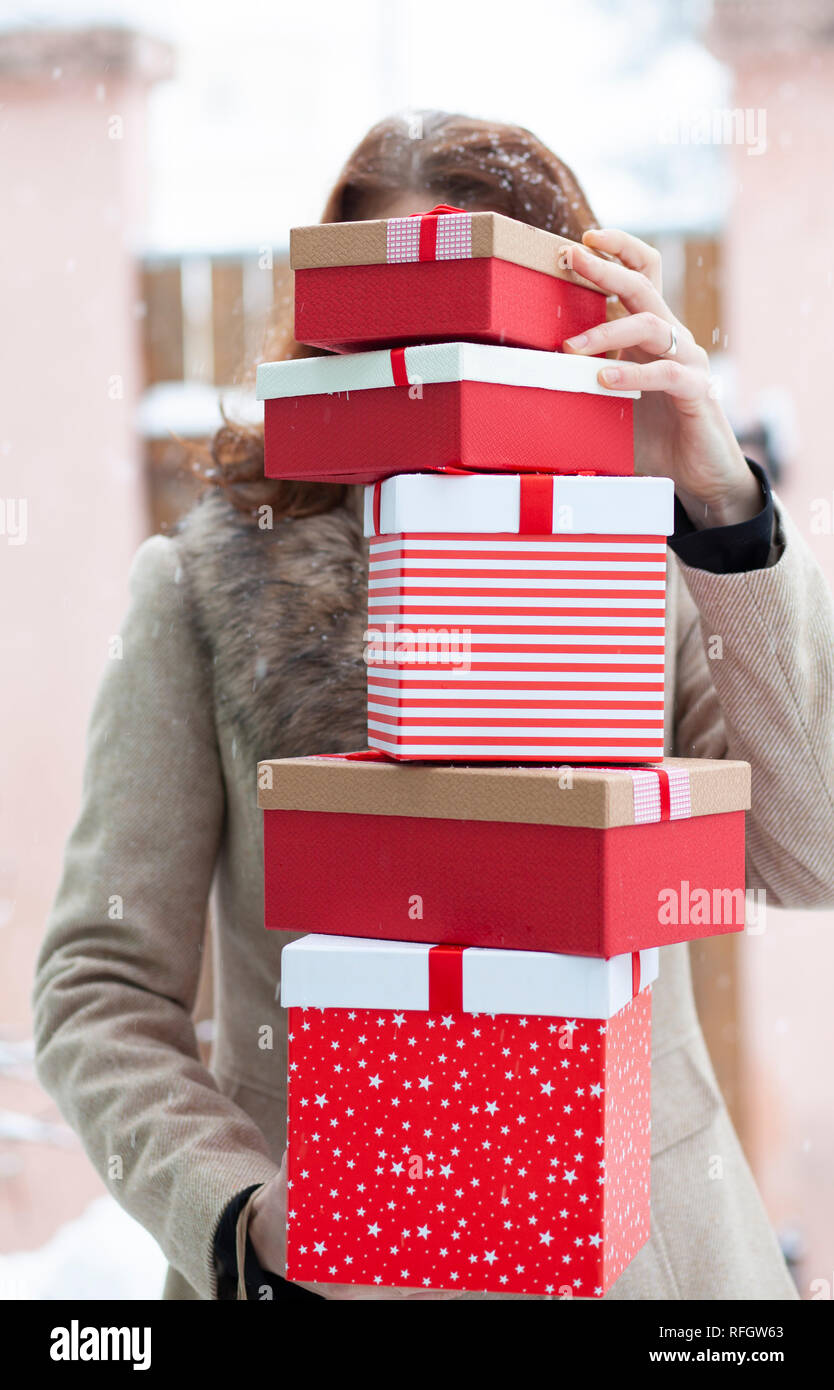 woman returning home from shopping holding pile of christmas present ...