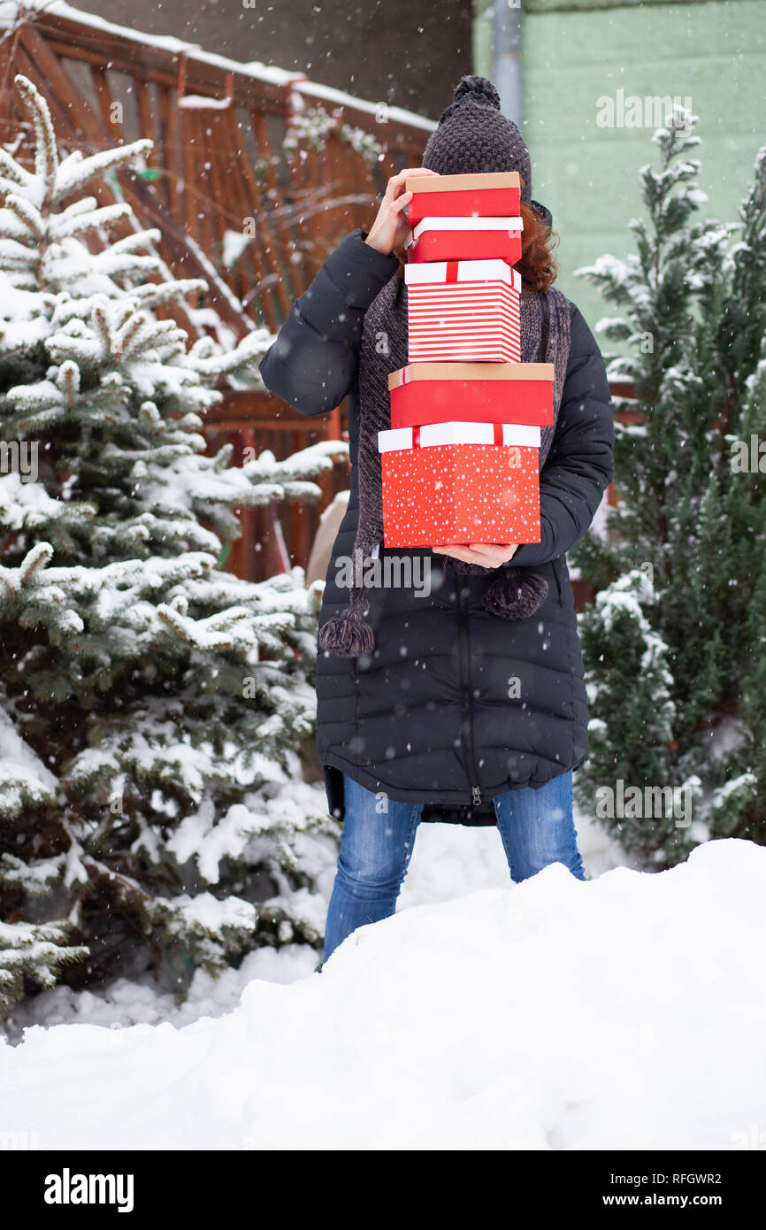 woman returning home from shopping holding pile of christmas present ...