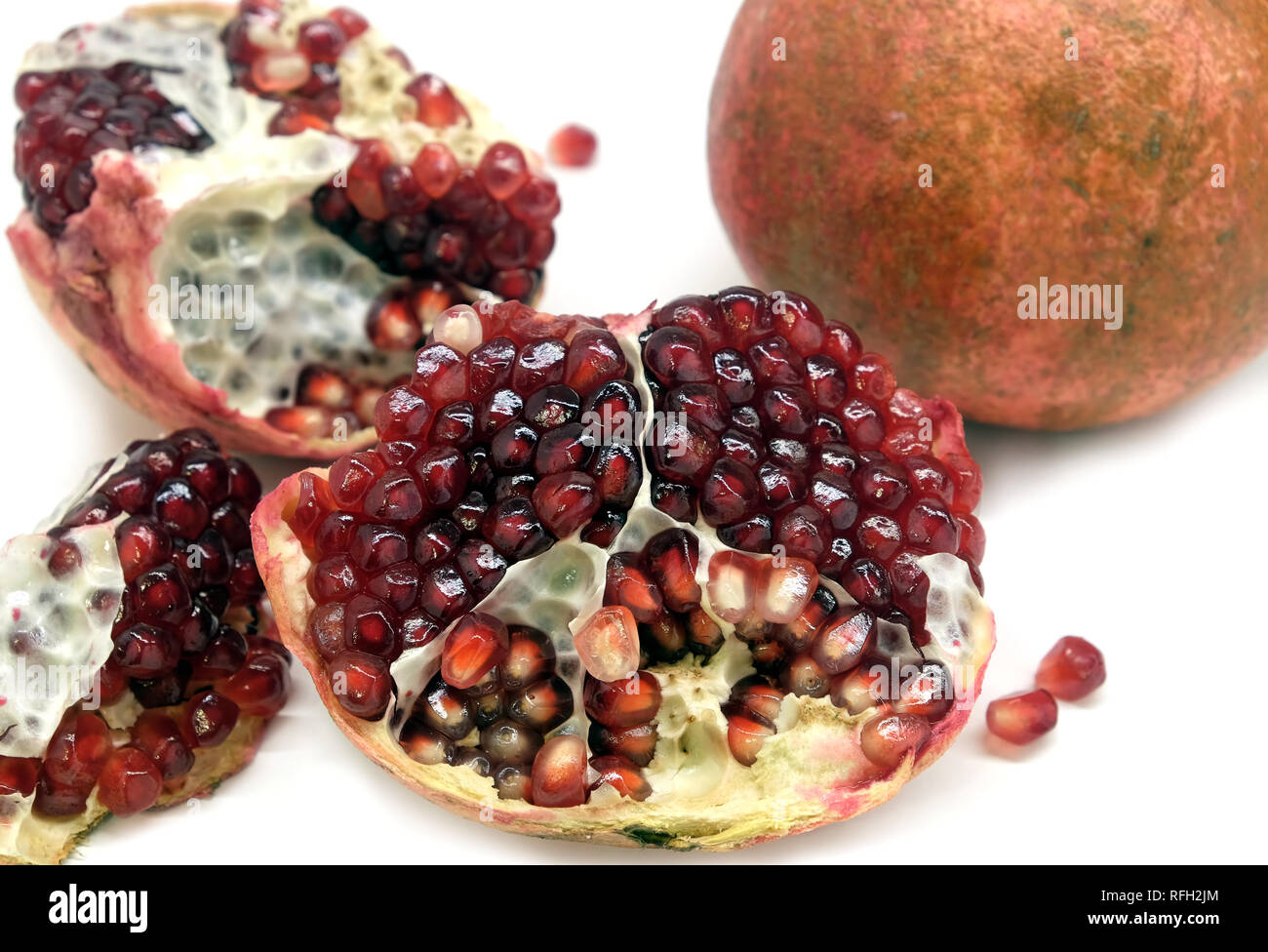 Whole and half pomegranates with ripe seeds isolated on white ...