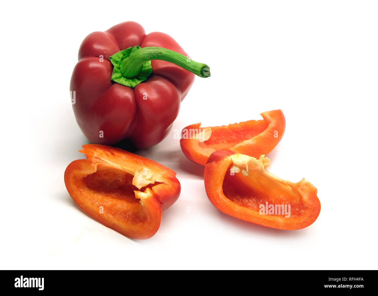 Still life with two whole and sliced red ripe bell peppers isolated on ...