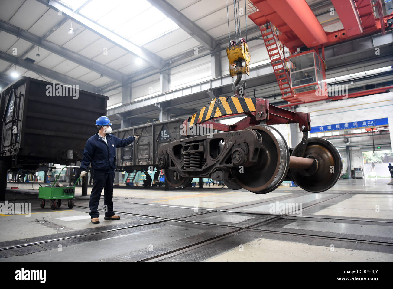 Chongqing. 25th Jan, 2019. A crane lifts the bogie of cargo train under ...