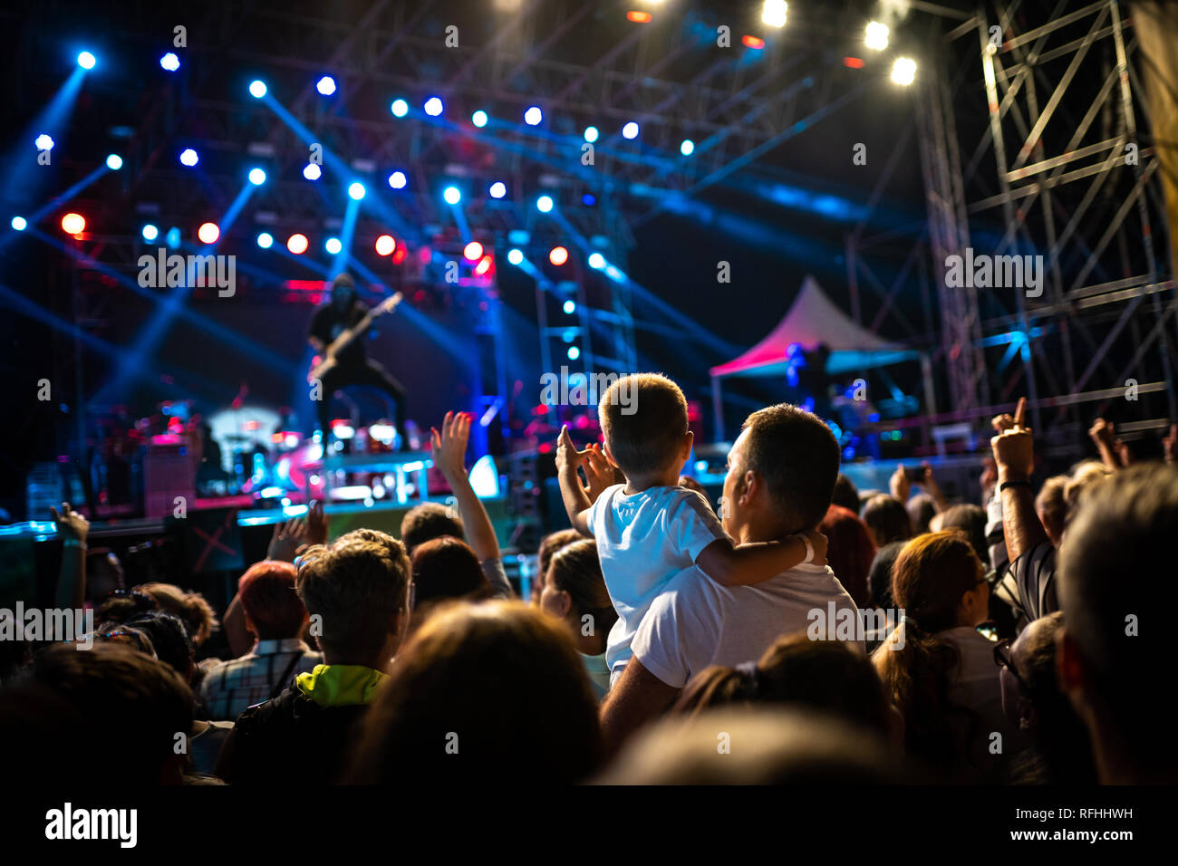 Concert seen from the crowds with a young boy and his father watching ...