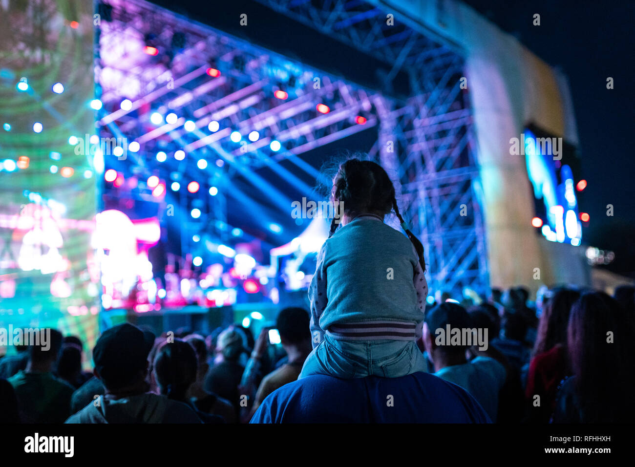 Young girl watching a concert from her dad shoulders Stock Photo - Alamy