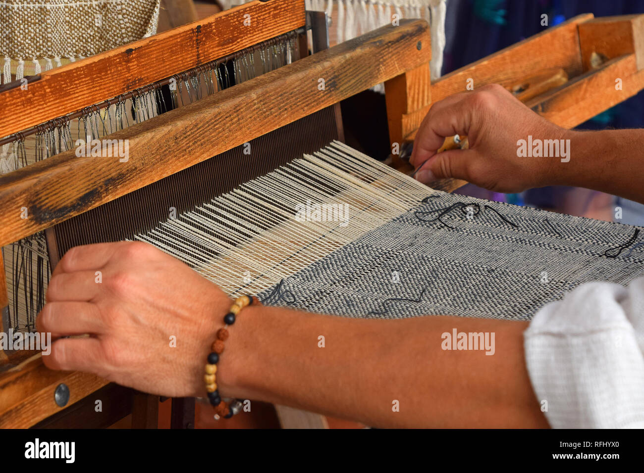 Close up man hands weave canvas with antique loom handweave machine ...