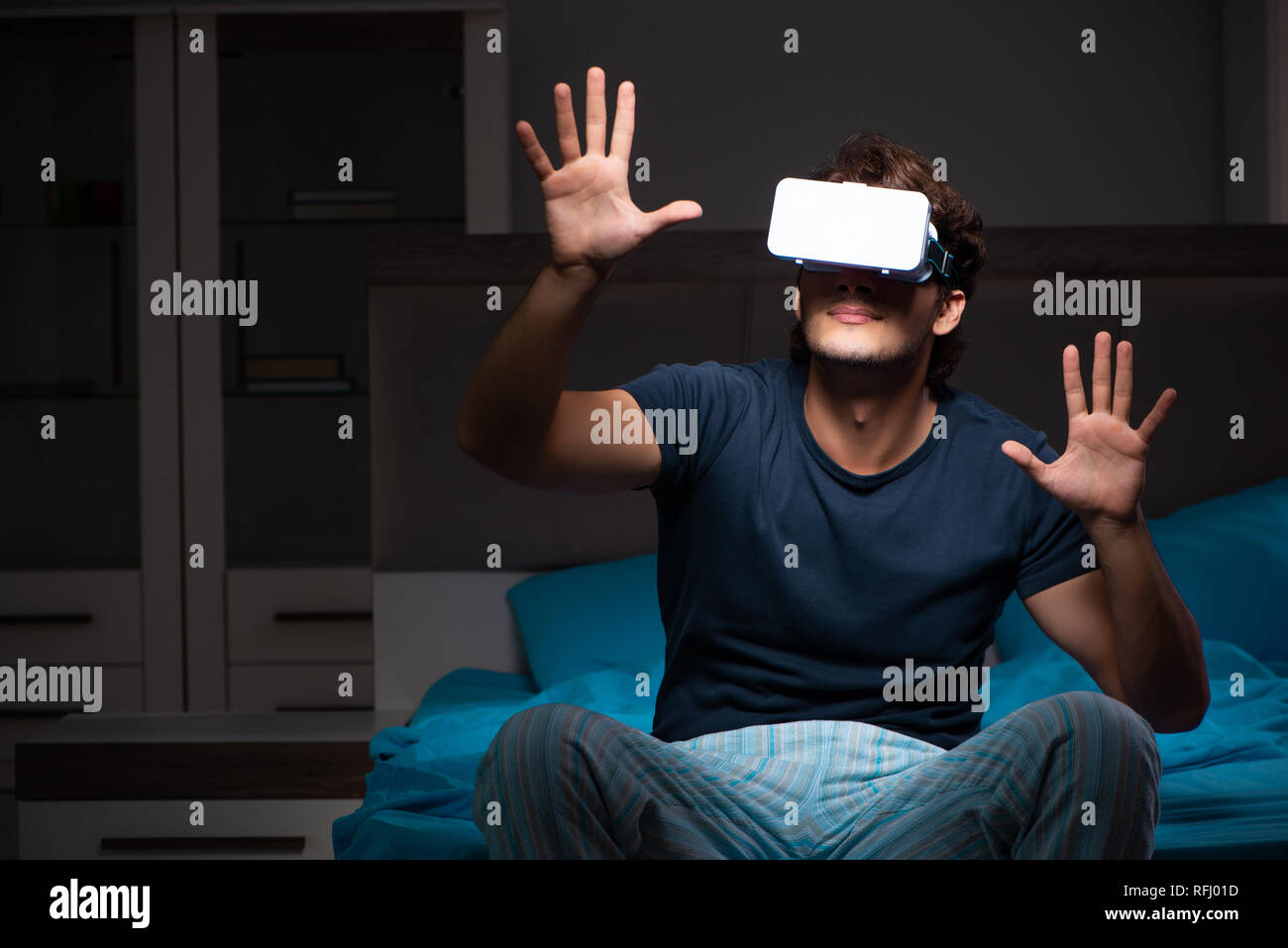 Young man playing computer games at night in bed Stock Photo - Alamy