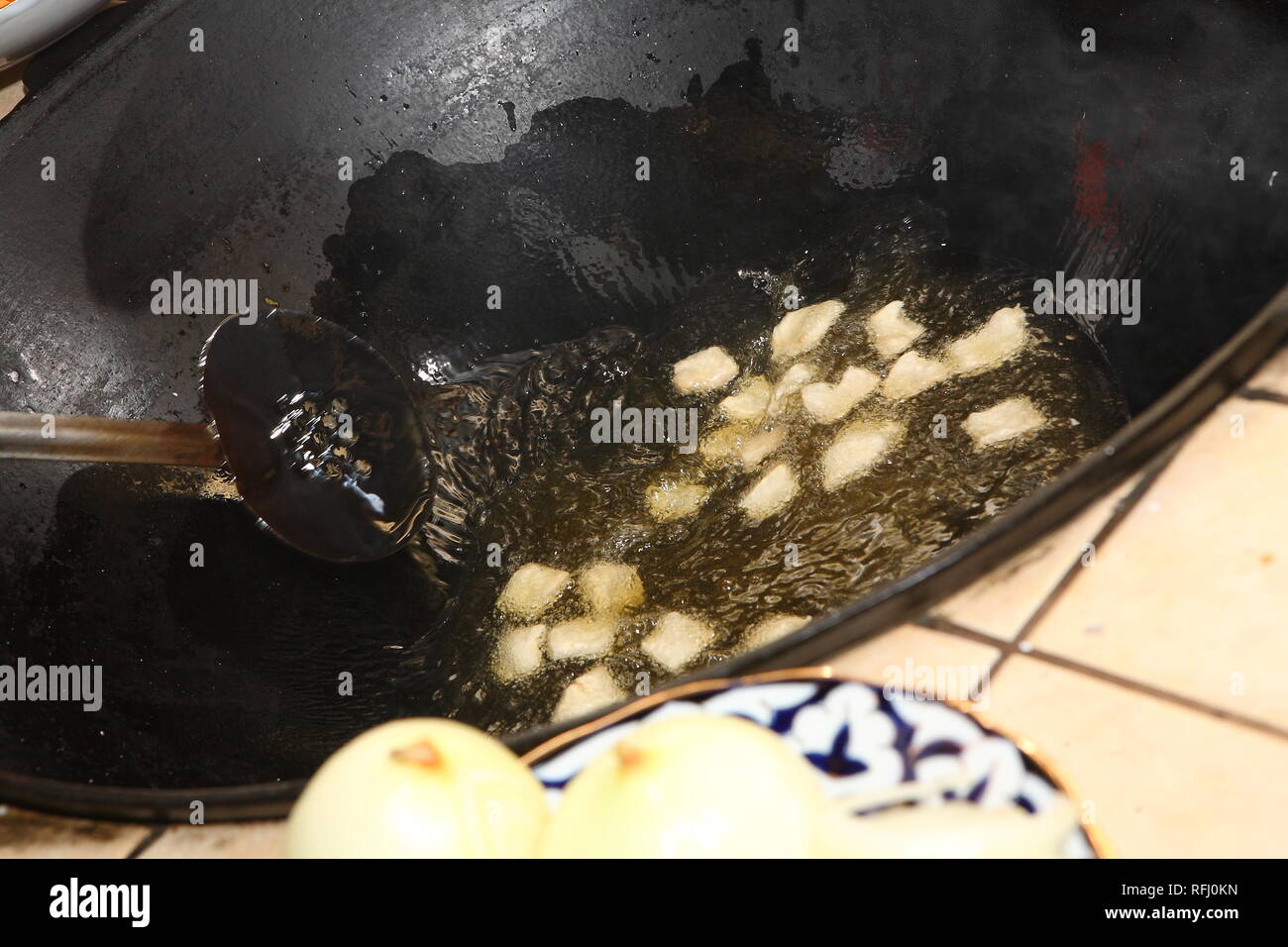 Cooking pilau in the kitchen of an oriental restaurant. Boils fat in a ...