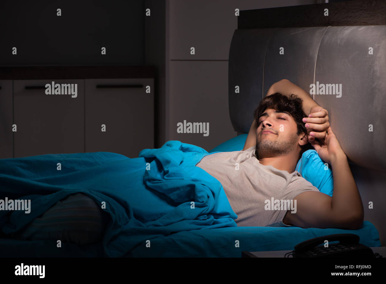 Tired exhausted man sleeping in his bed Stock Photo - Alamy