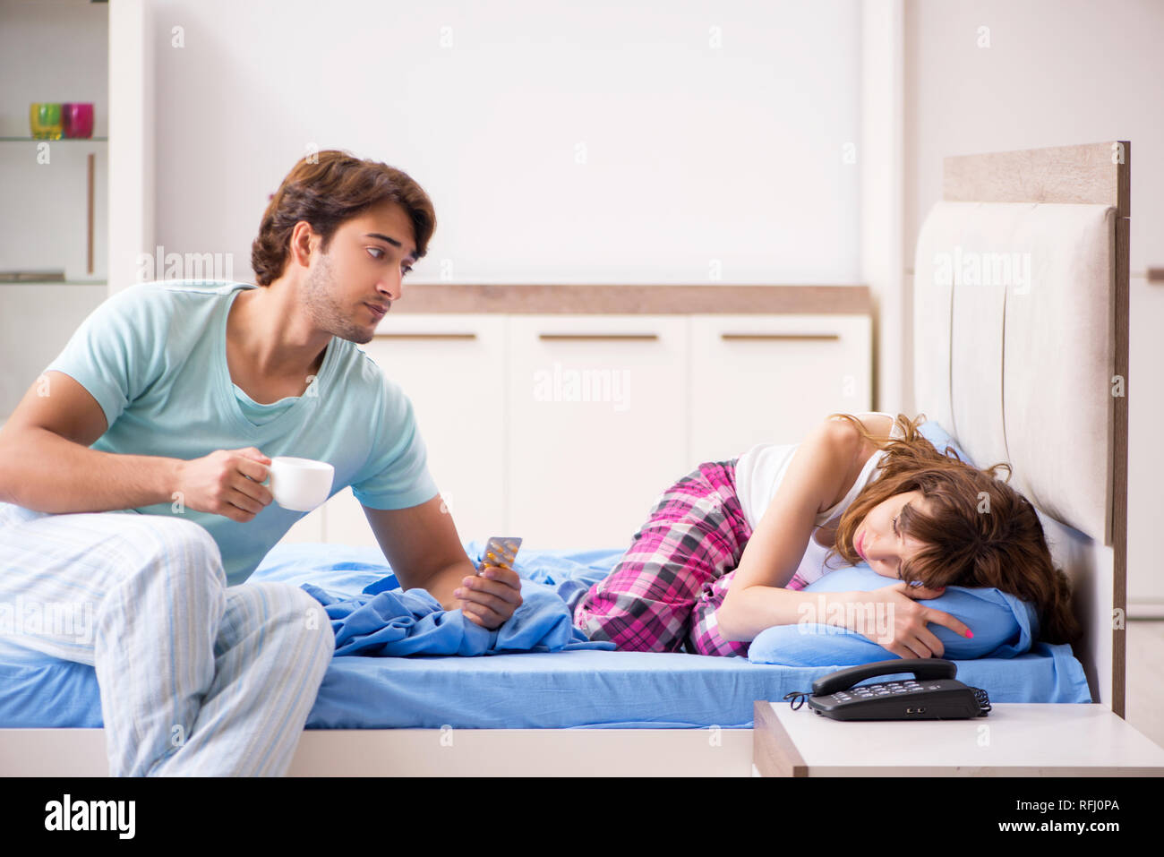 Young husband looking after sick wife in the bedroom Stock Photo - Alamy