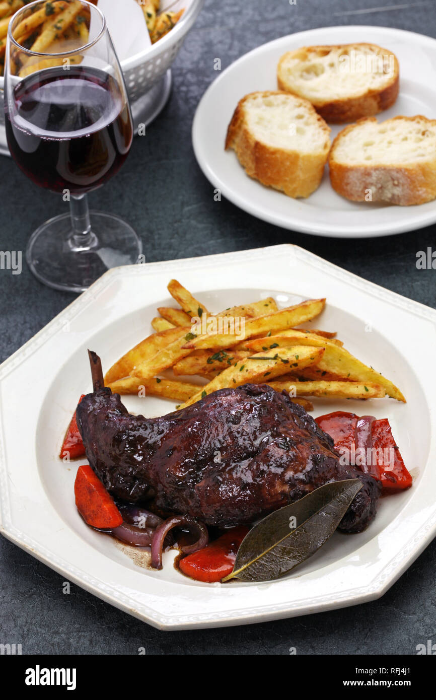 rabbit cooked in red wine with french fries Stock Photo - Alamy