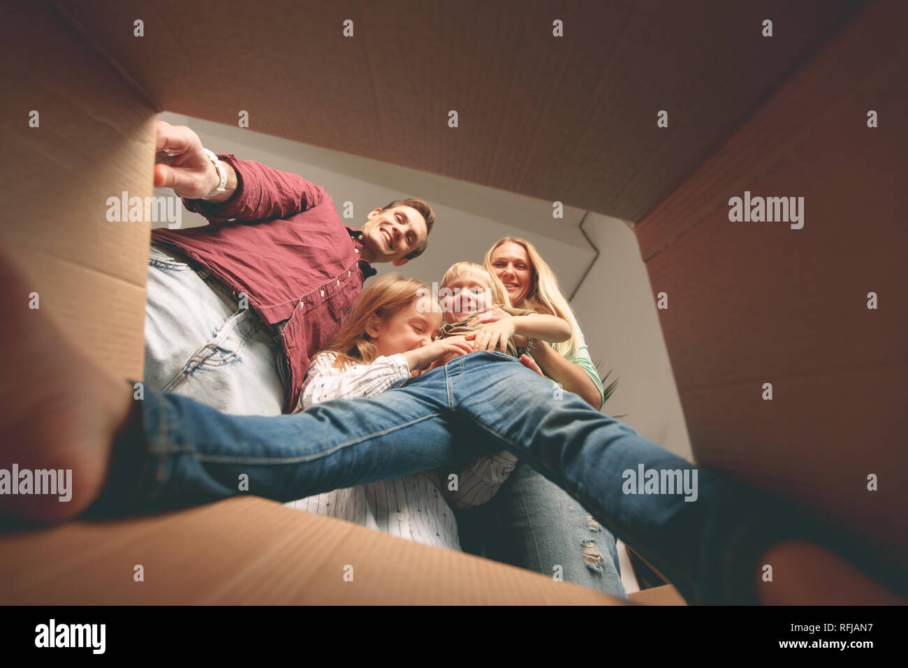 Image of parents, daughter and son looking inside cardboard box Stock ...