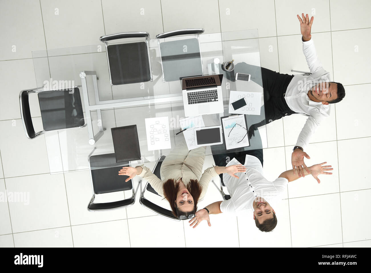 top view. happy employees sitting at the office Desk Stock Photo - Alamy