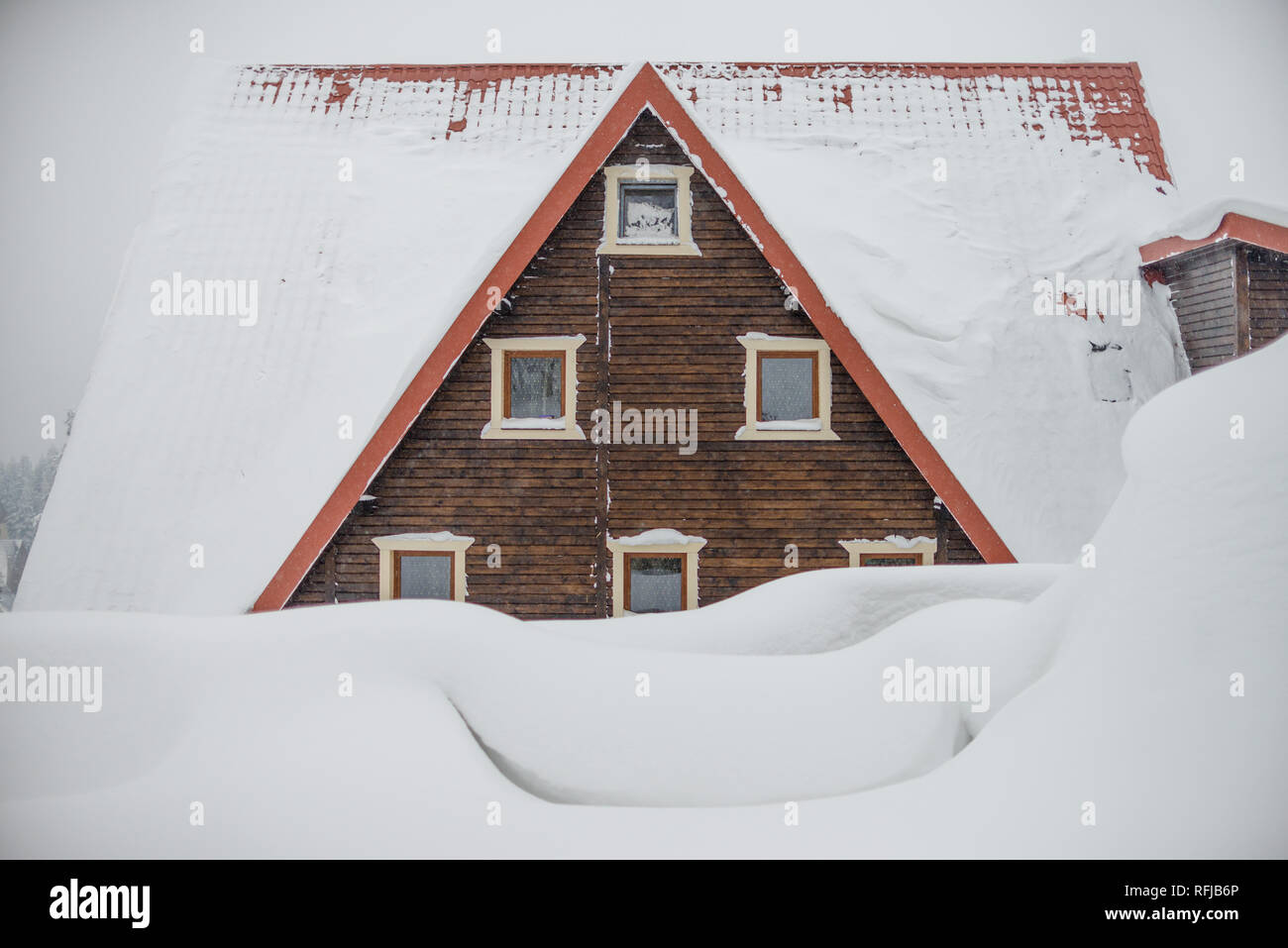 The roof of a wooden house. Large snow drifts. Triangular roof with ...
