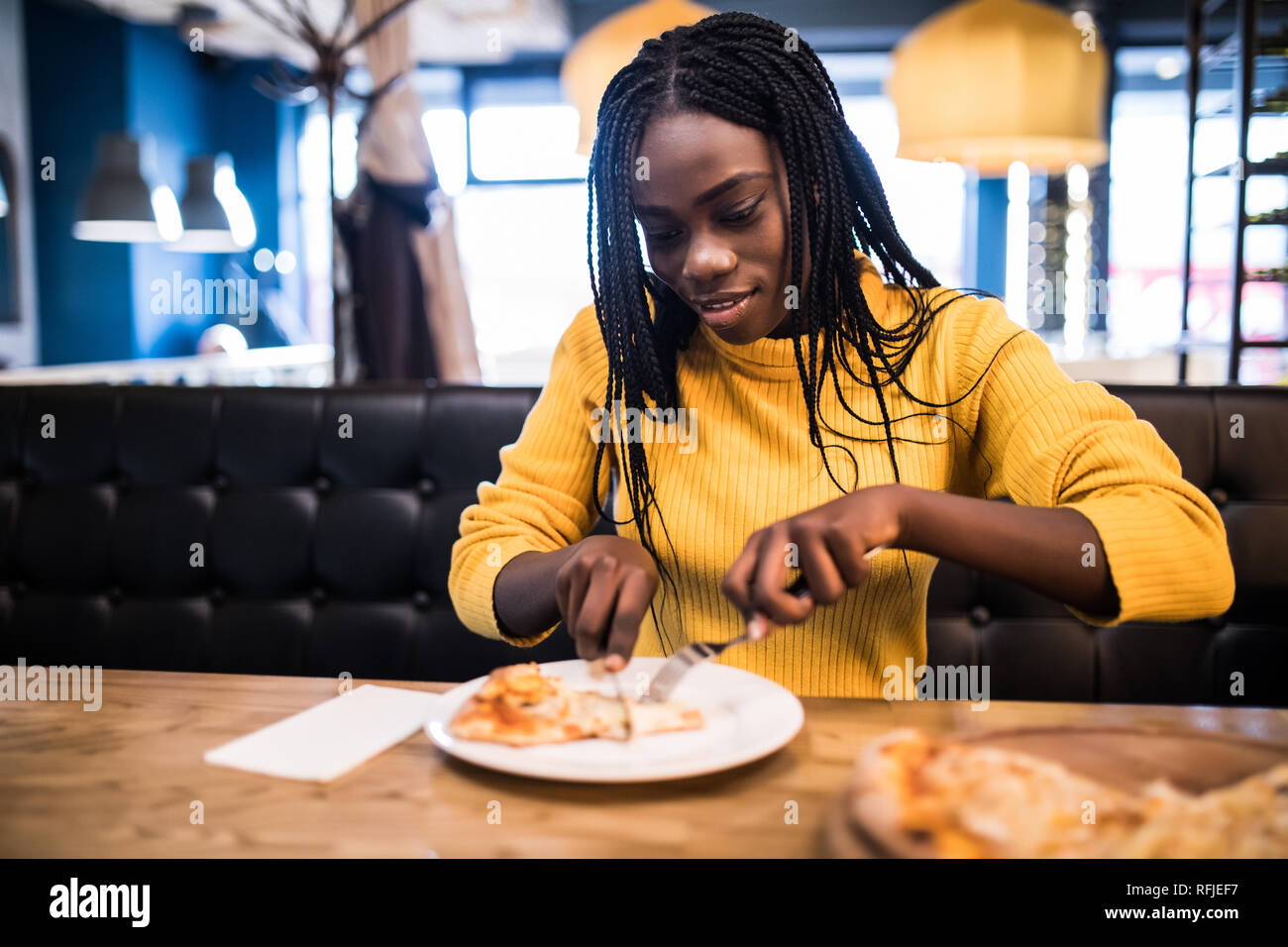 Girl eating pizza in yellow hi-res stock photography and images - Alamy