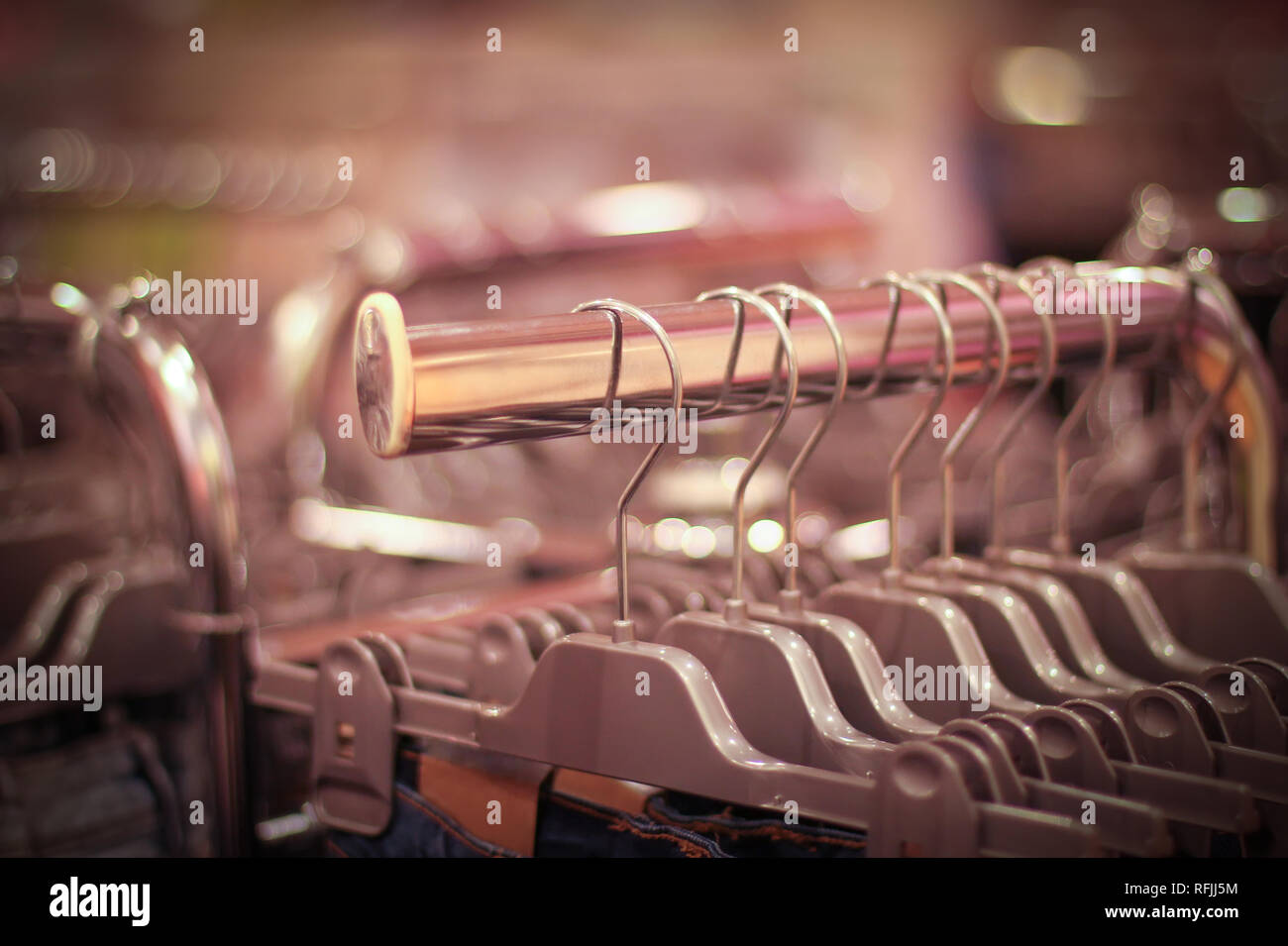 Wear hanging on rack in clothing store Stock Photo - Alamy