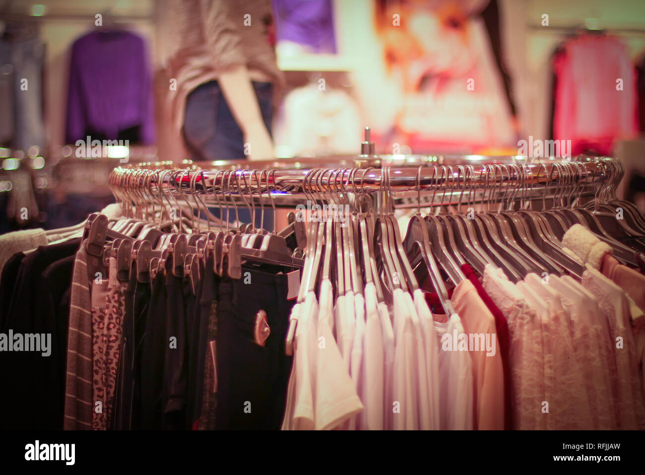 Wear hanging on rack in clothing store Stock Photo - Alamy