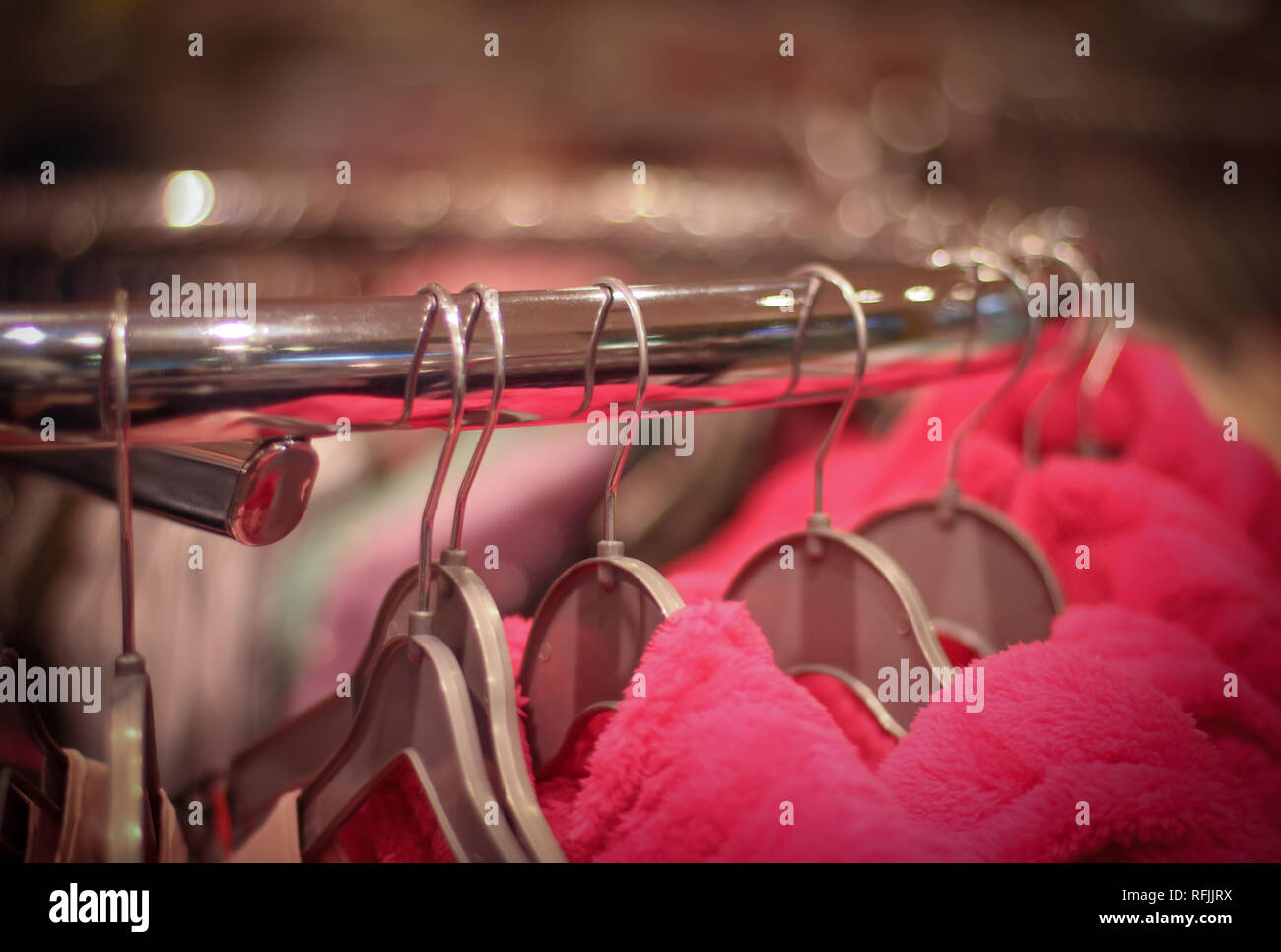Wear hanging on rack in clothing store Stock Photo - Alamy