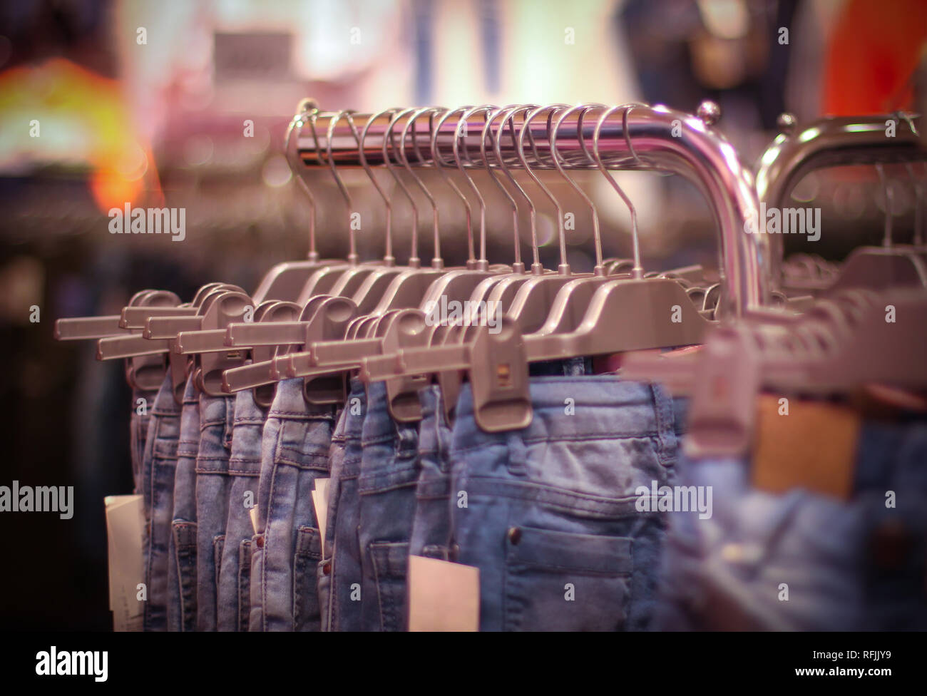 Wear hanging on rack in clothing store Stock Photo - Alamy