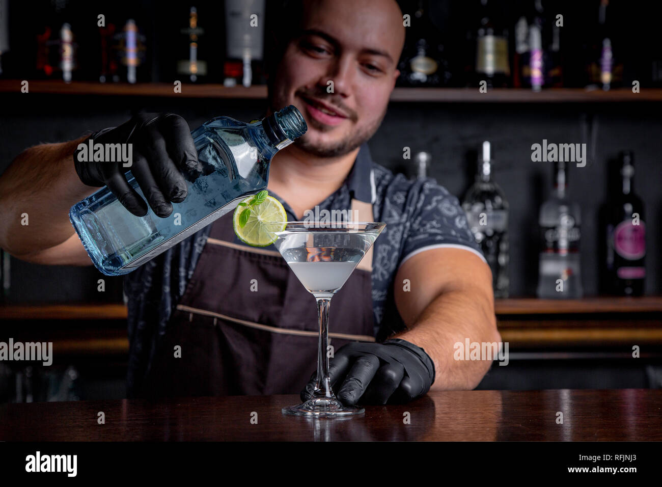 barman preparing and pouring cocktail in martini class Stock Photo - Alamy