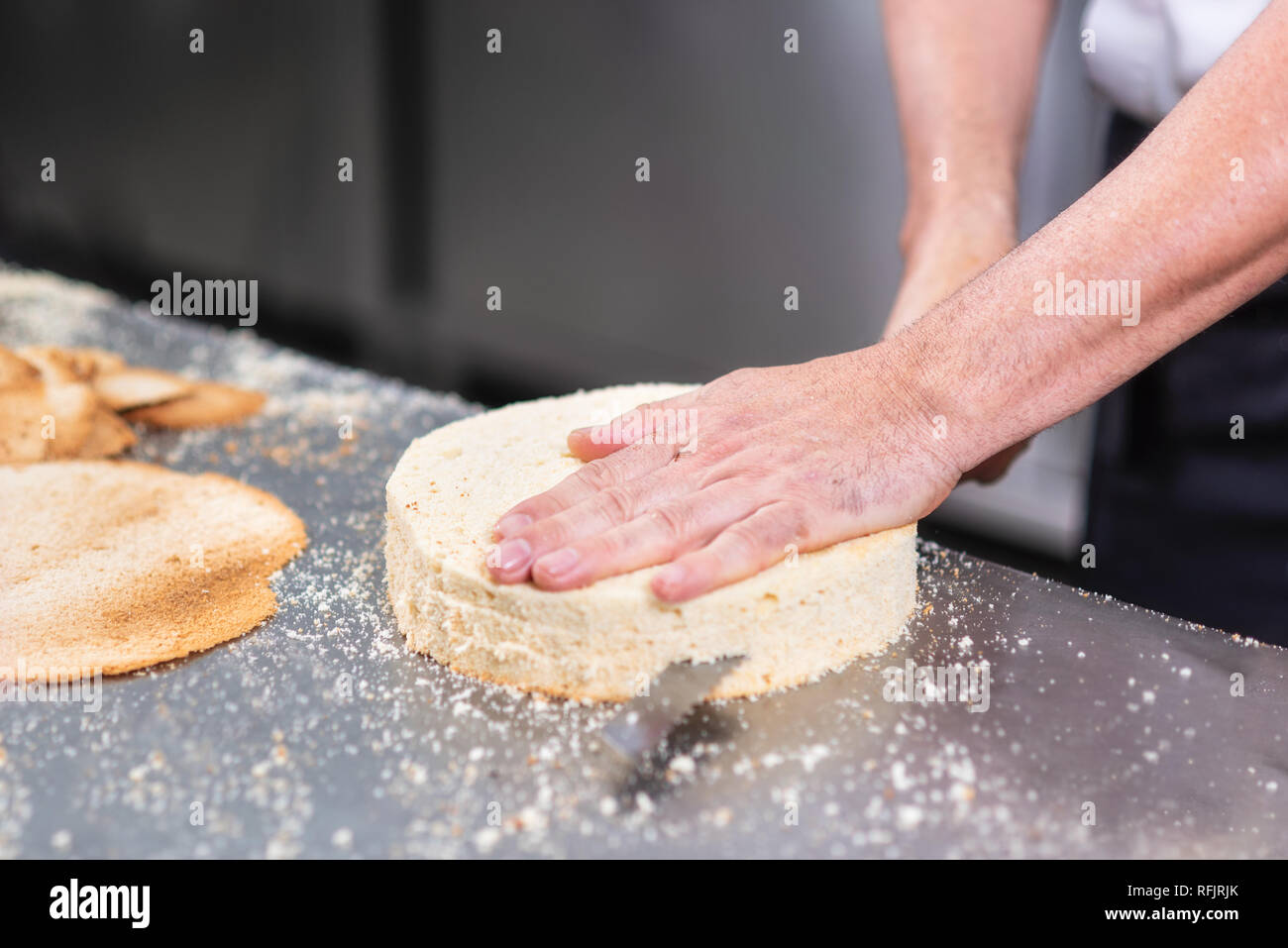 pastry chef cutting the sponge cake on layers. Cake production process ...