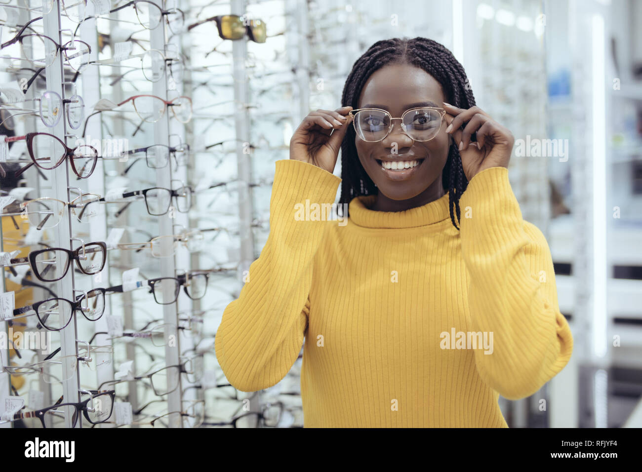 Young african woman choosing prescription glasses frames in Optician's ...