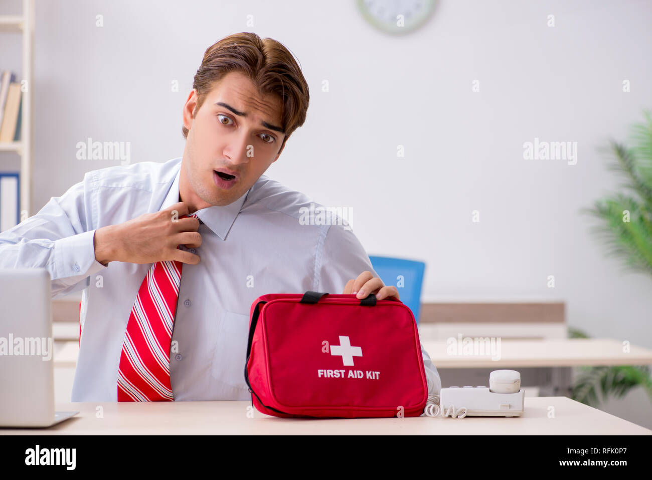 Man with first aid kit in the office Stock Photo - Alamy