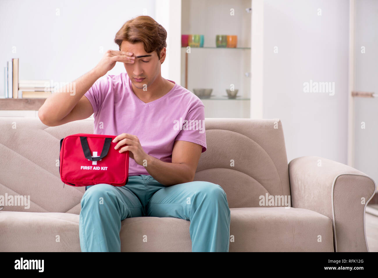 Sick man at home with first aid kit Stock Photo - Alamy