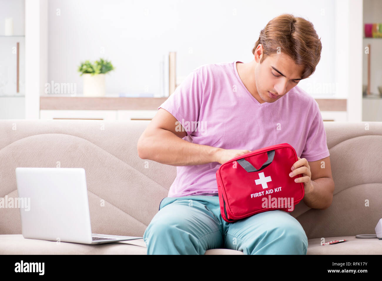 Sick man at home with first aid kit Stock Photo - Alamy
