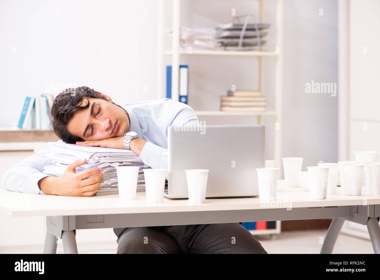 Young employee addicted to coffee Stock Photo - Alamy