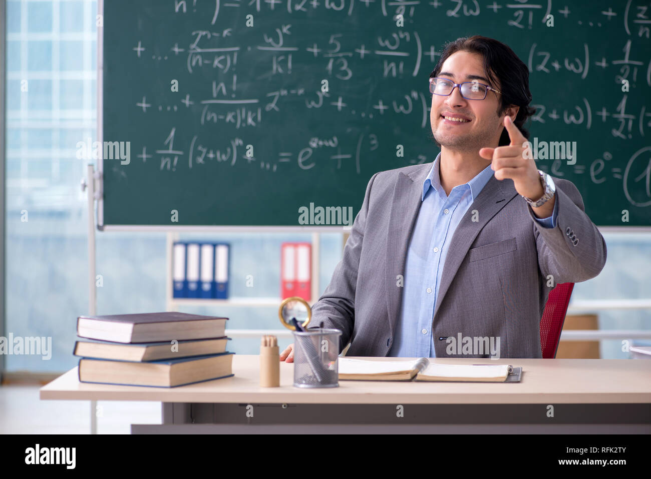 Young handsome math teacher in classroom Stock Photo - Alamy