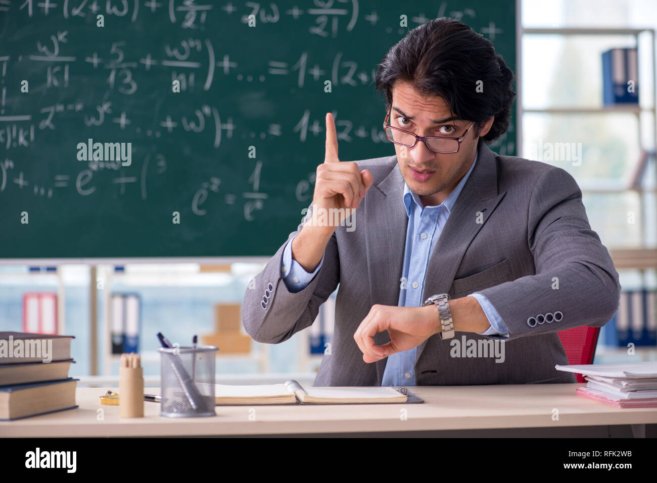 Young handsome math teacher in classroom Stock Photo - Alamy