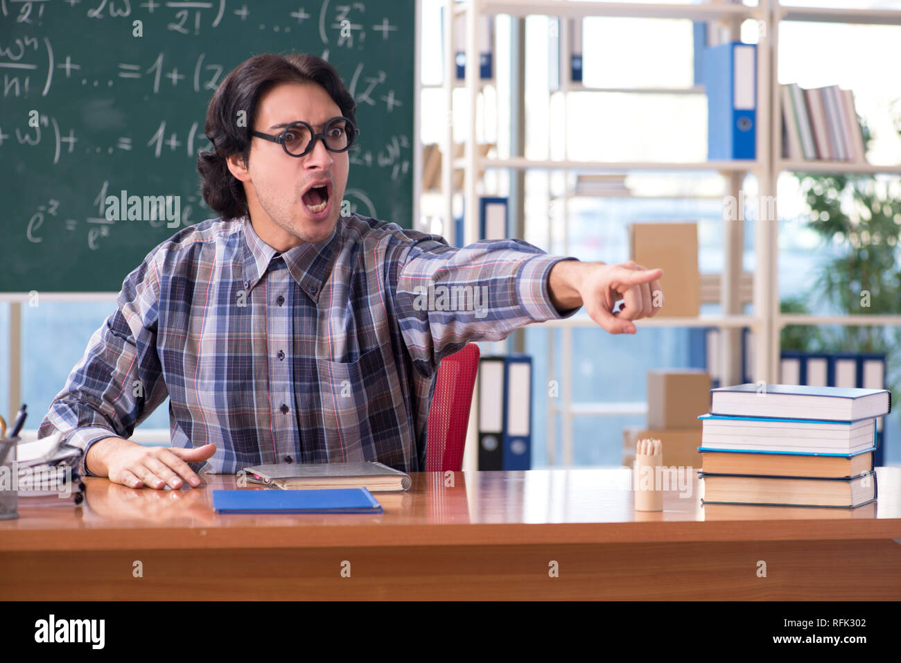 Young funny math teacher in front of chalkboard Stock Photo - Alamy
