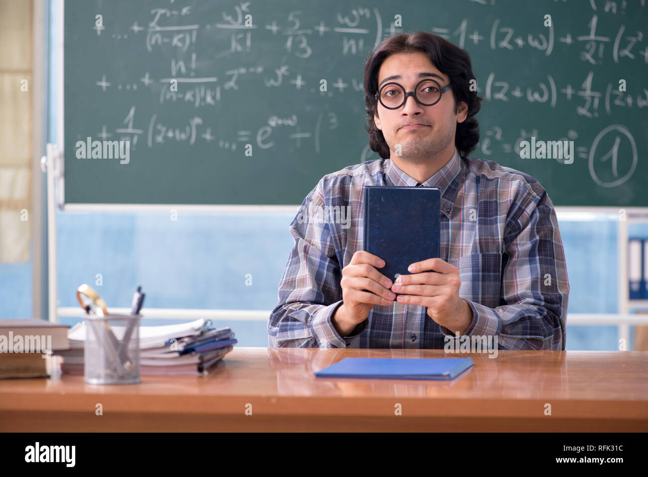 Young funny math teacher in front of chalkboard Stock Photo - Alamy