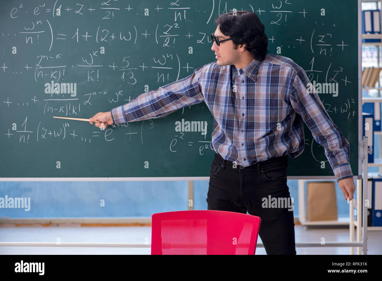 Young funny math teacher in front of chalkboard Stock Photo - Alamy
