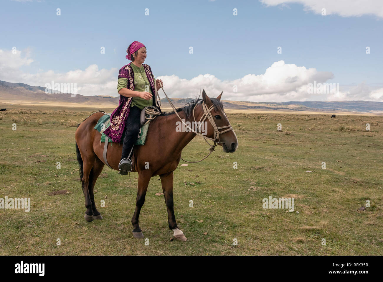 Woman herder riding across the high steppes of Assy Plateau, Kazakhstan ...