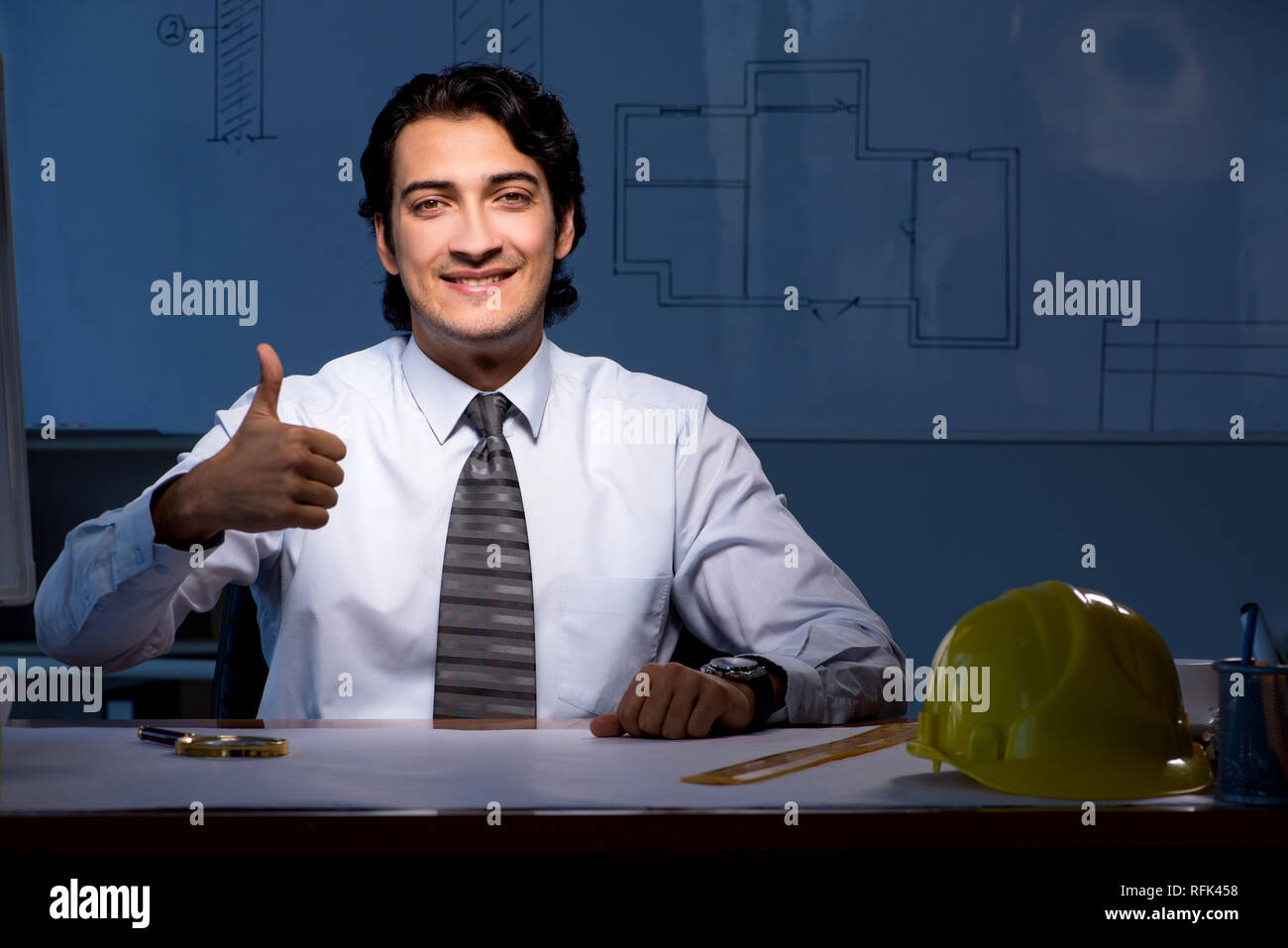 Young construction architect working on project at night Stock Photo ...