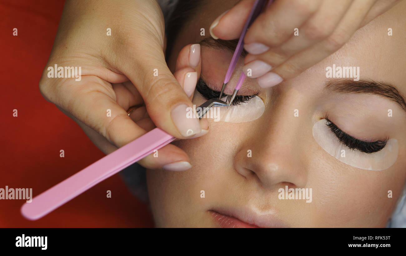 Cosmetic procedure for eyelash extensions in spa salon. Beautician ...