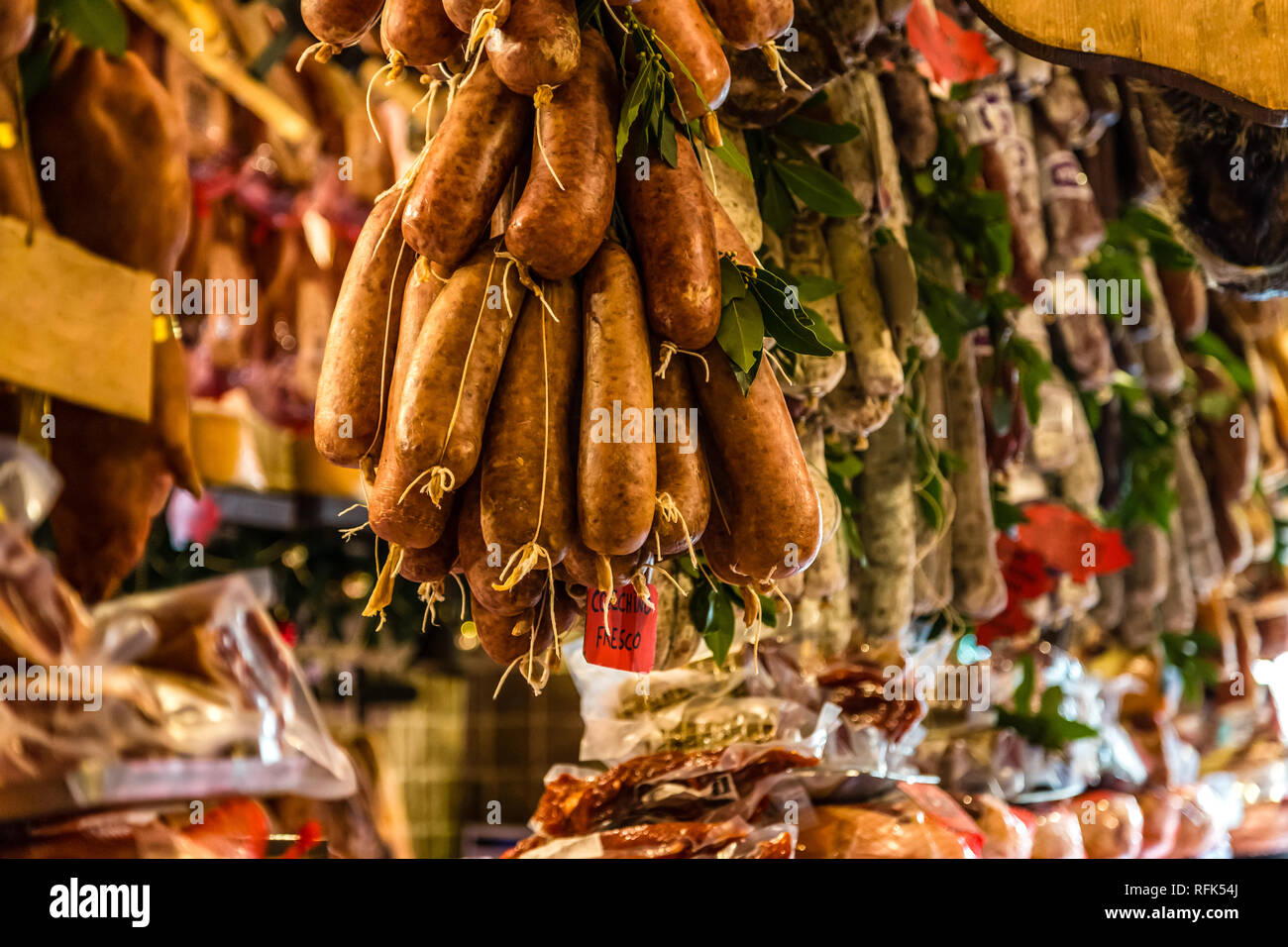 hanged salami for sale in gourmet shop in Italy. The label in Italian ...