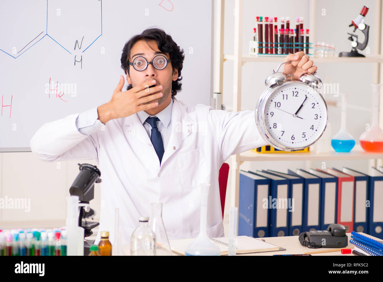 Young funny chemist in front of white board Stock Photo - Alamy
