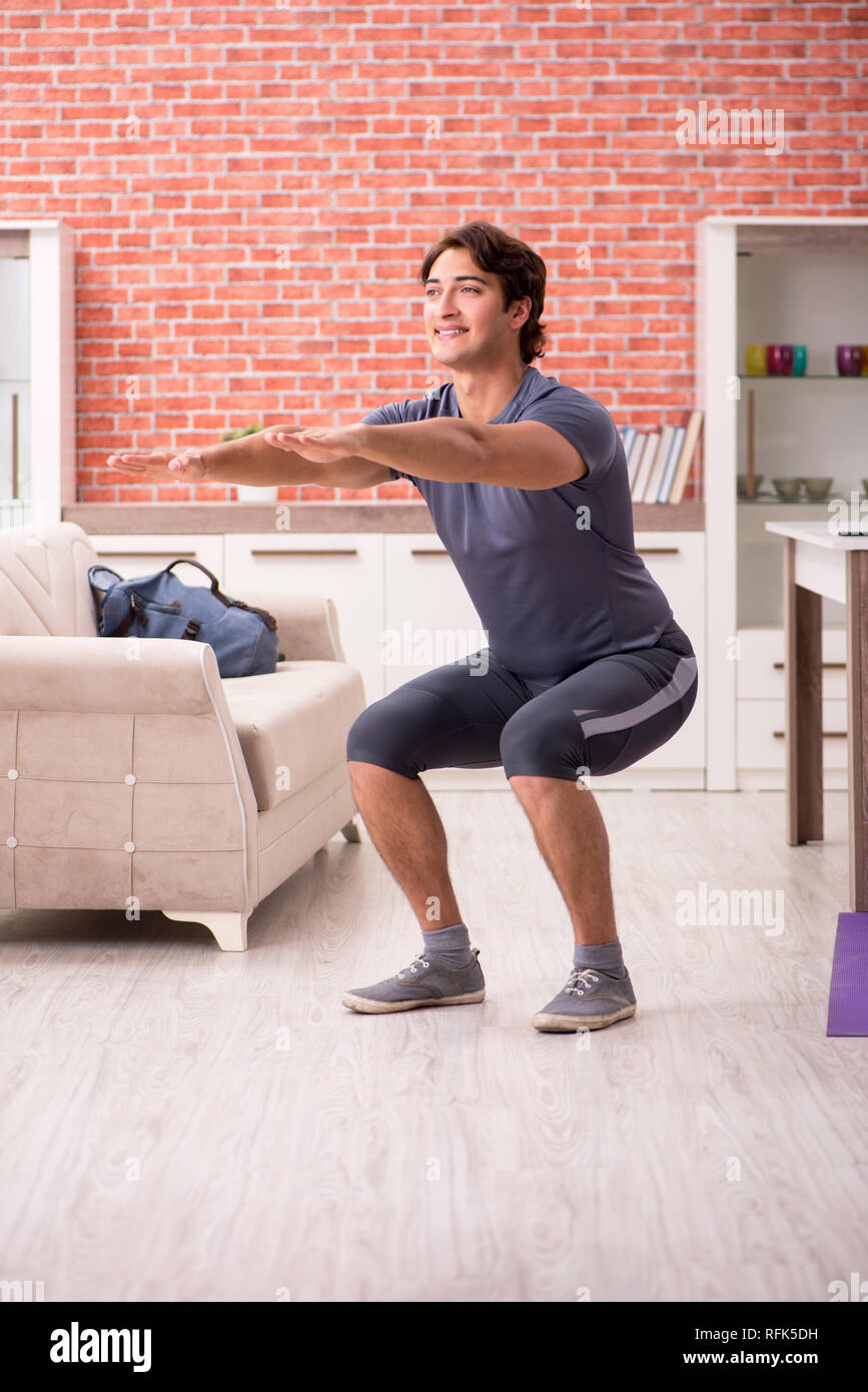 Young handsome man doing sport exercises at home Stock Photo - Alamy