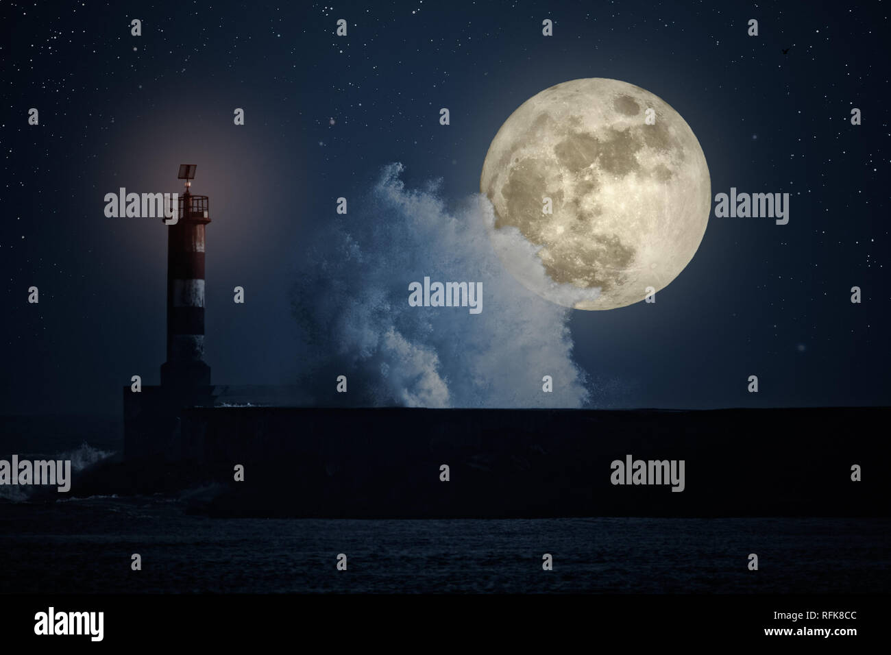 Big stormy wave breaking over pier and beacon in a full moon night ...