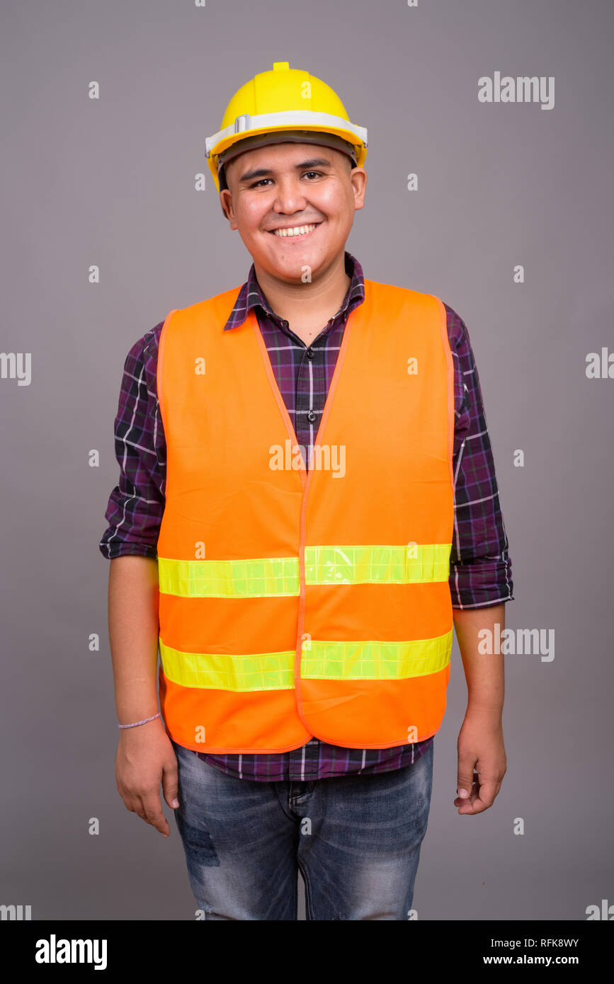Young Asian man construction worker against gray background Stock Photo ...