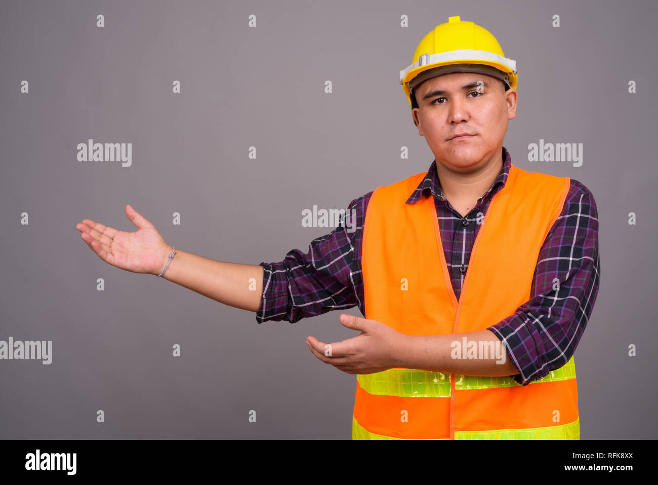 Young Asian man construction worker against gray background Stock Photo ...