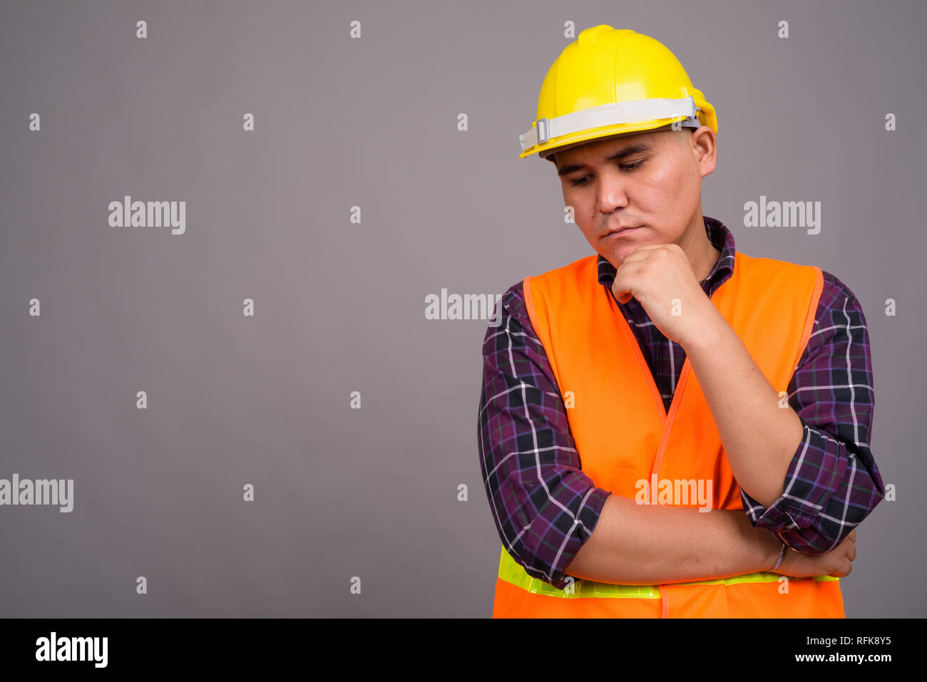 Young Asian man construction worker against gray background Stock Photo ...