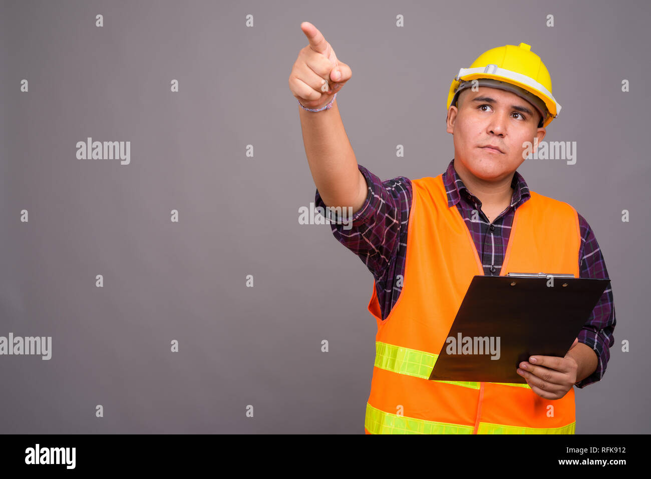 Young Asian man construction worker against gray background Stock Photo ...