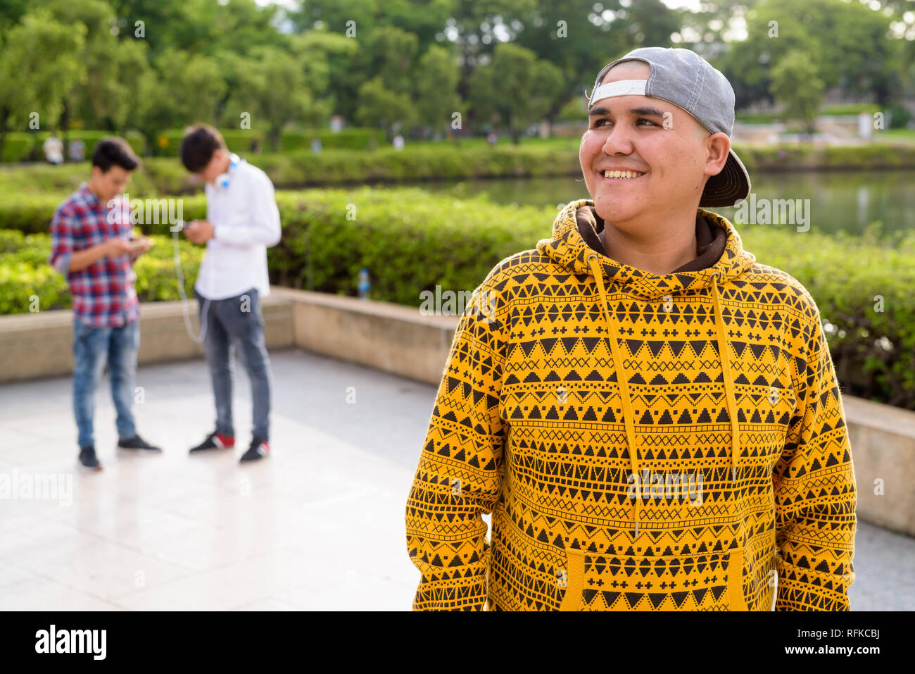 Three young Asian men relaxing at the park together Stock Photo - Alamy